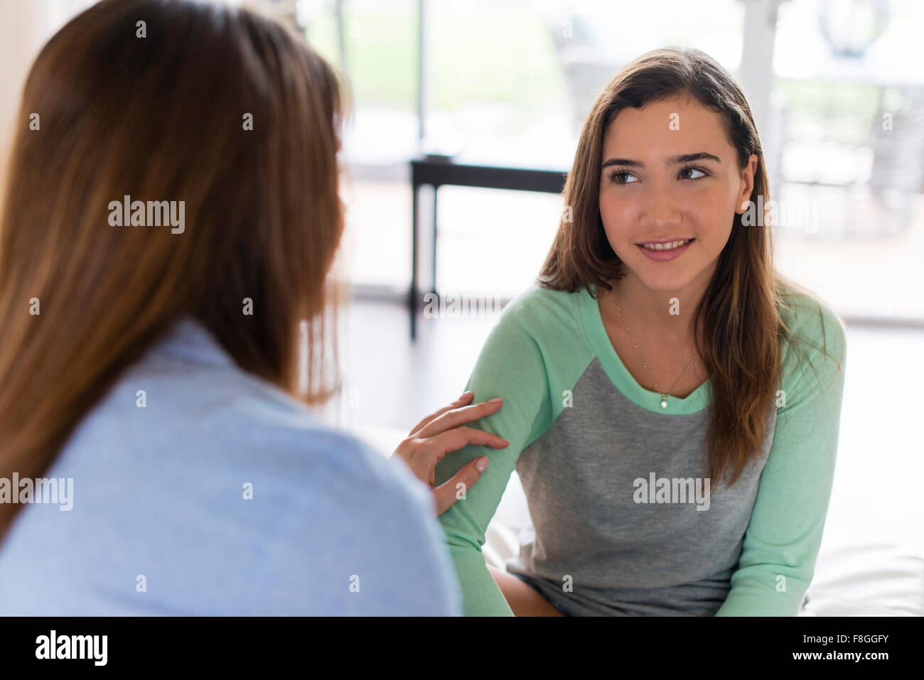 Mother and daughter talking indoors Stock Photo - Alamy