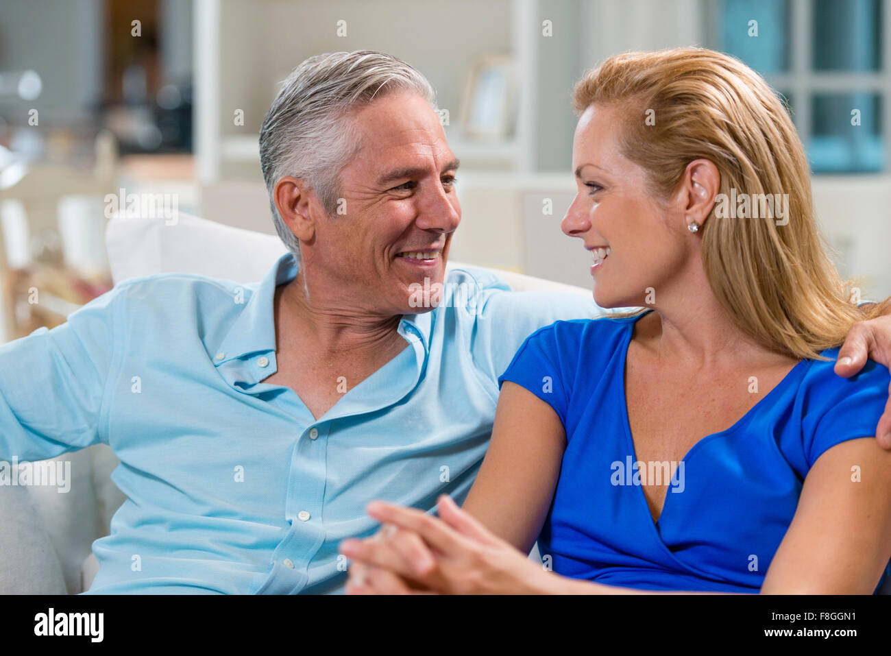 Caucasian couple talking on sofa Stock Photo - Alamy