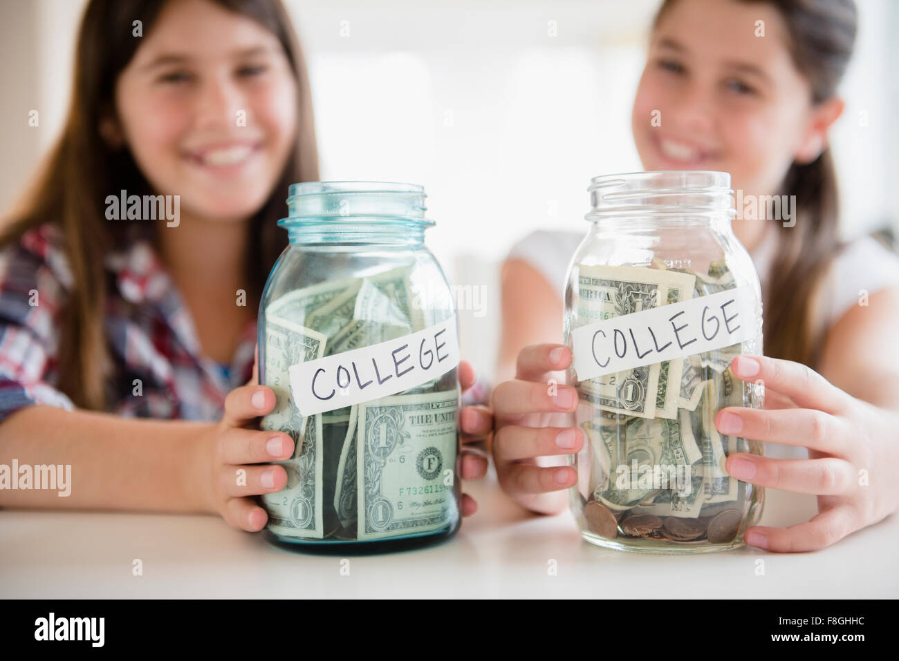 Caucasian twin sisters saving for college Stock Photo - Alamy