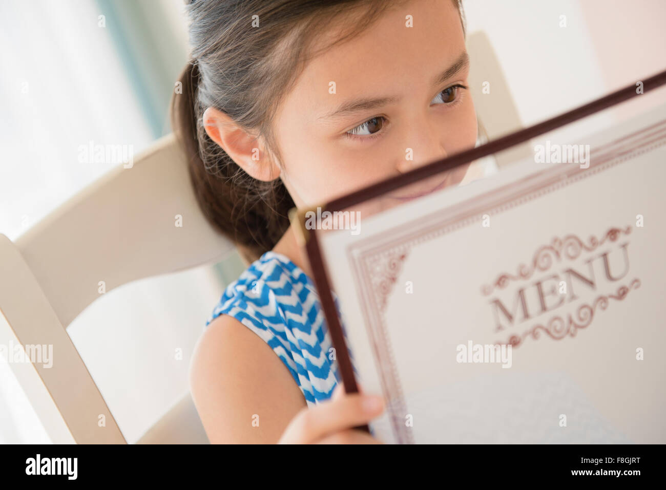 Girl reading menu in restaurant Stock Photo - Alamy
