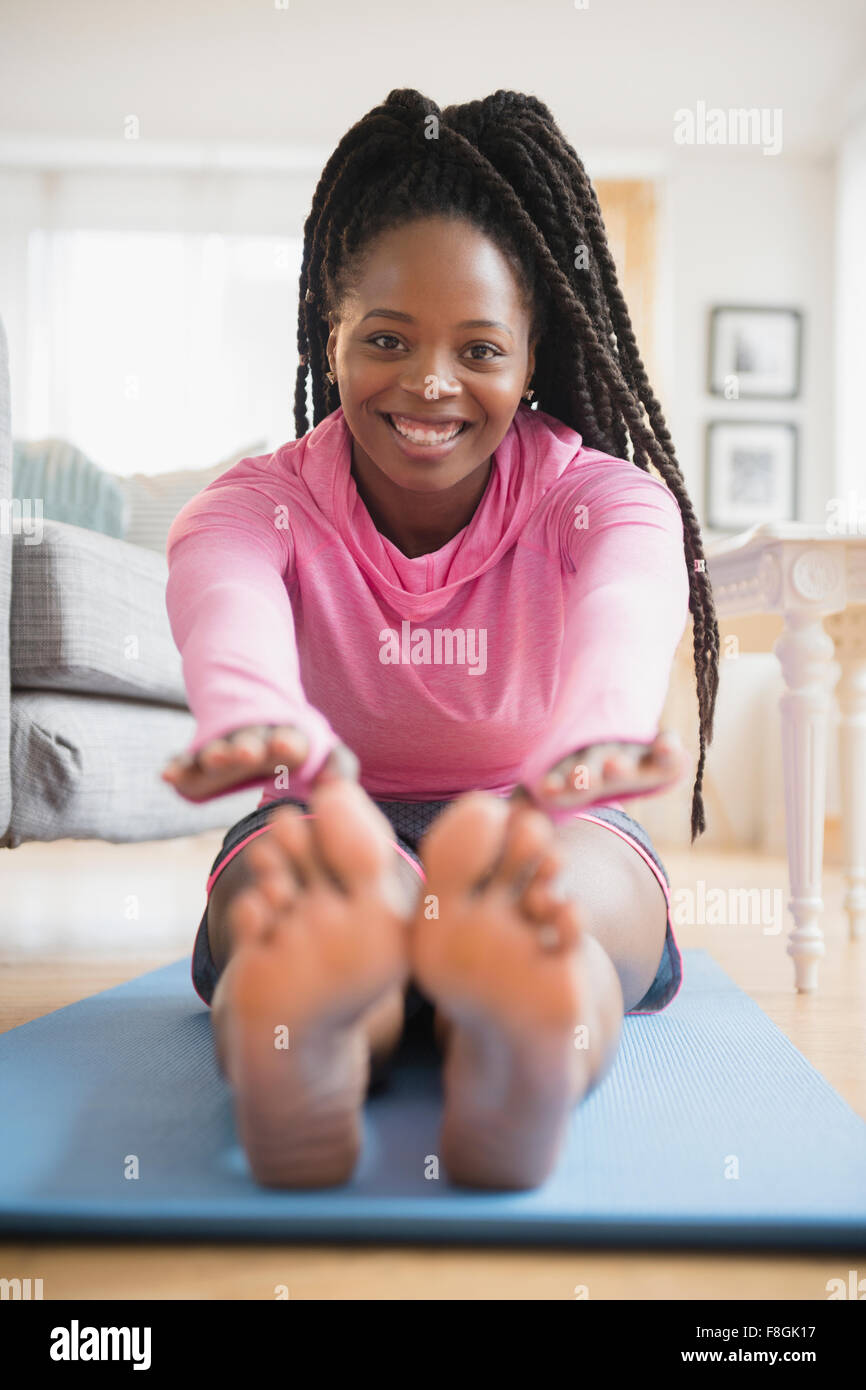Black woman practicing yoga in living room Stock Photo - Alamy