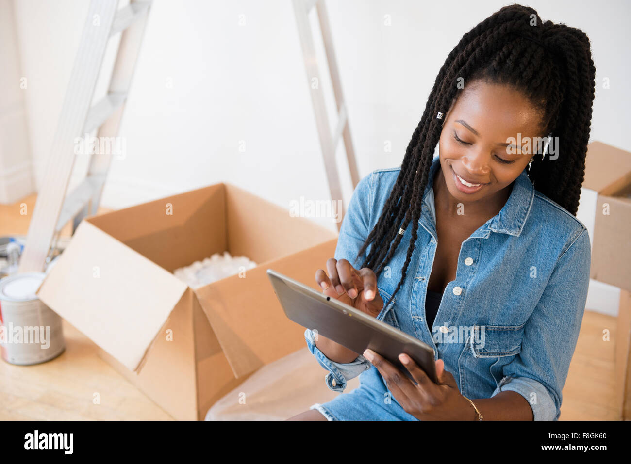 Black woman using digital tablet in new home Stock Photo - Alamy