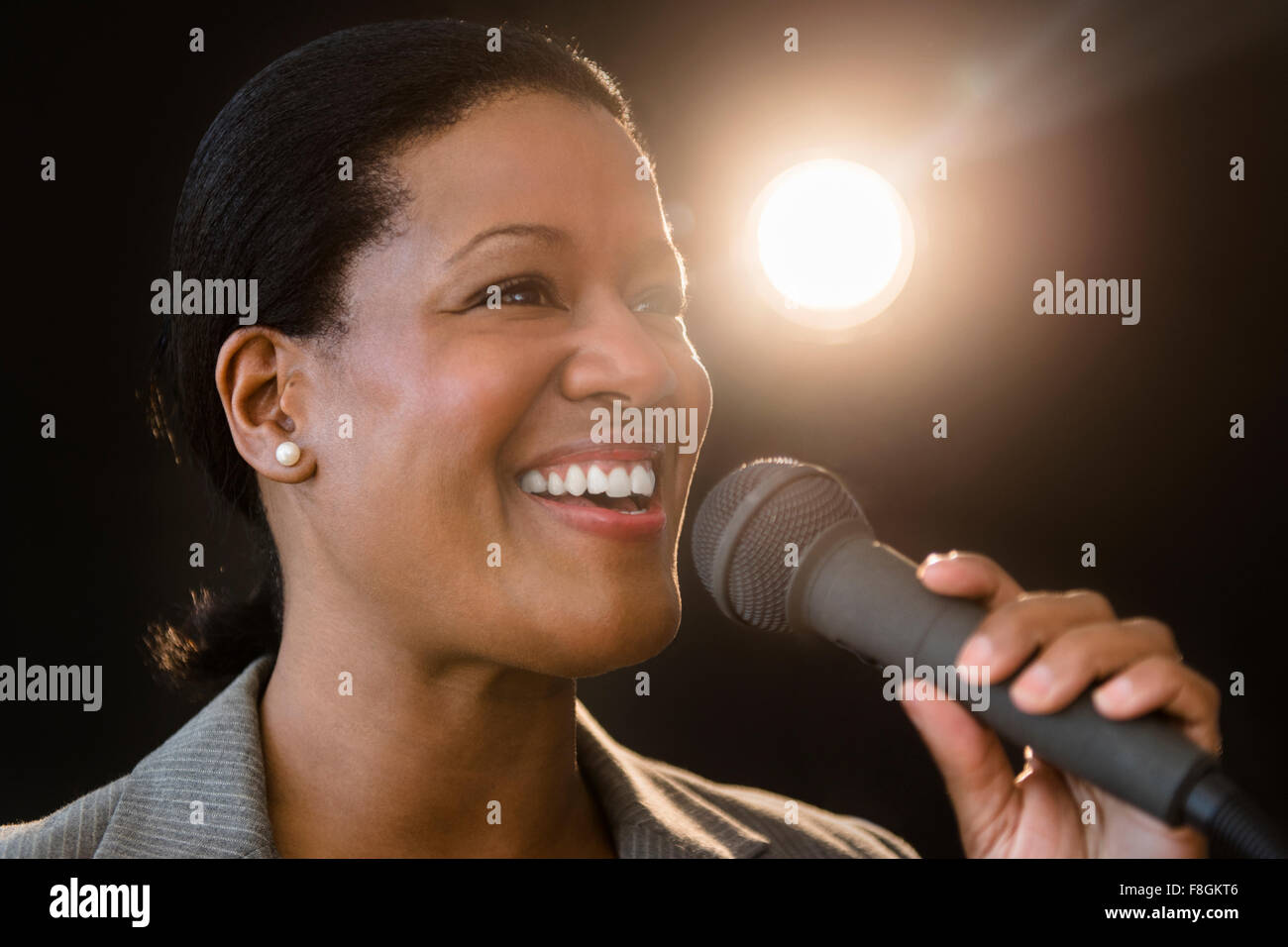Black businesswoman talking into microphone Stock Photo - Alamy