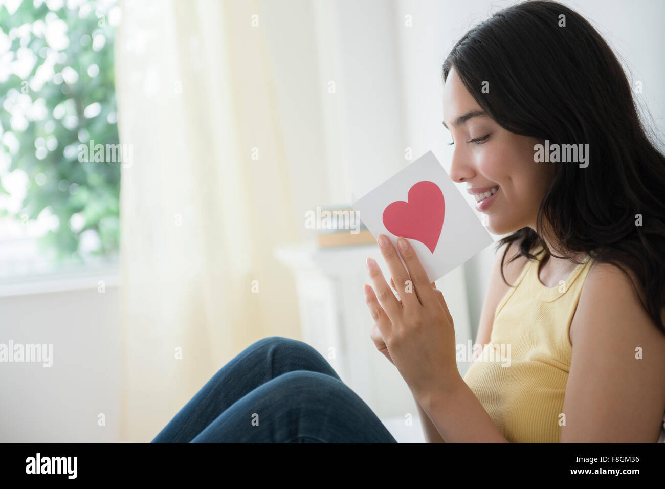 Hispanic woman reading romantic card Stock Photo - Alamy