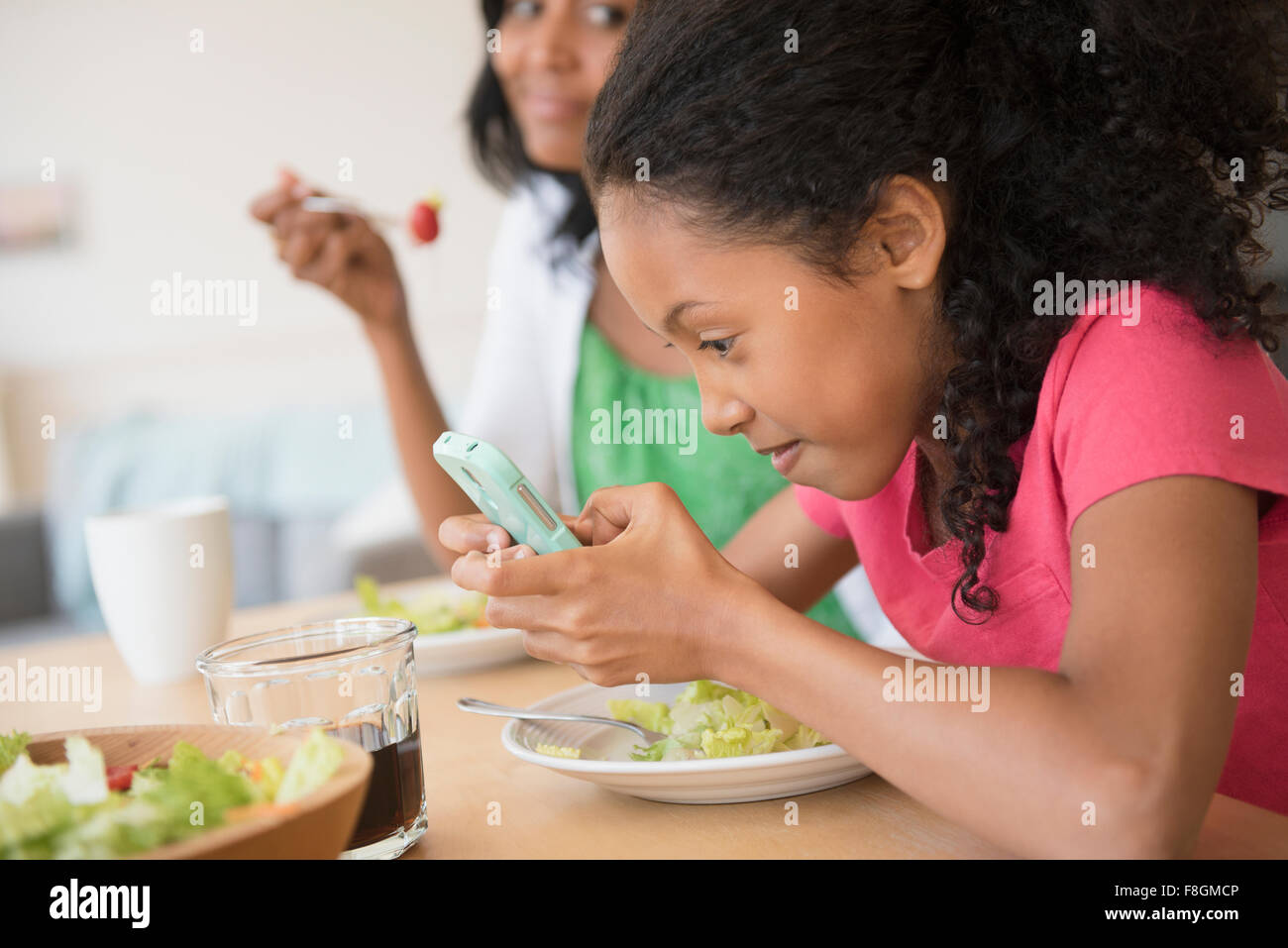 Using phone while eating family hi-res stock photography and images - Alamy