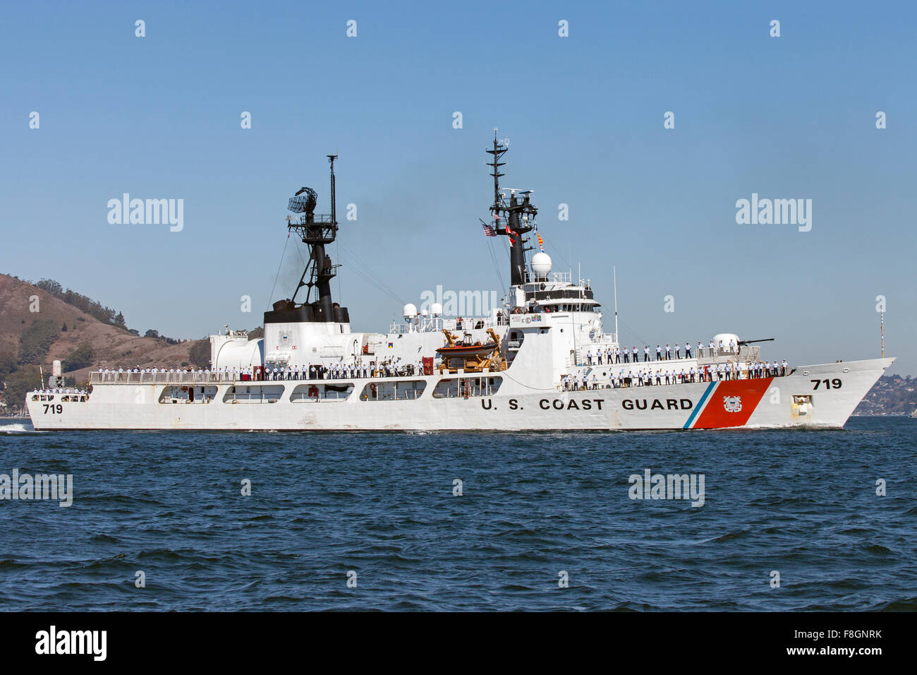 The crew of the Coast Guard Cutter Boutwell (WHEC 719) line the deck as ...