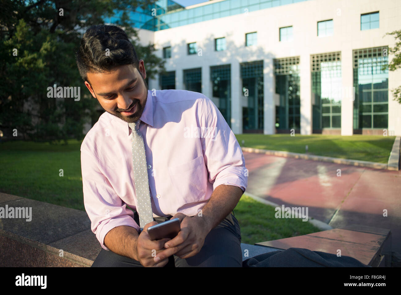 Indian businessman using cell phone outside office building Stock Photo ...