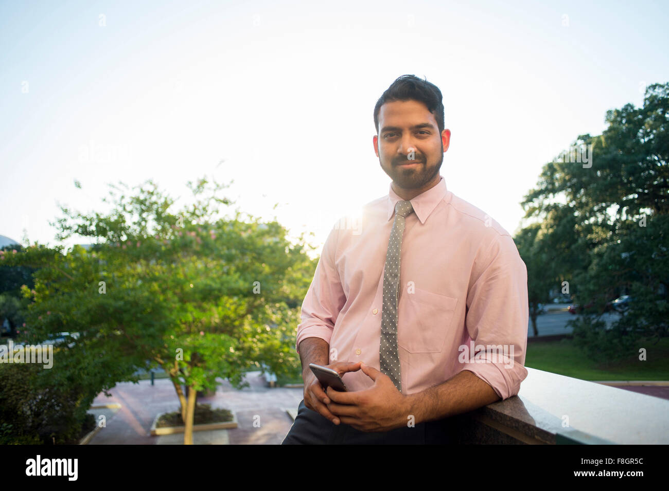 Indian businessman using cell phone on steps Stock Photo - Alamy