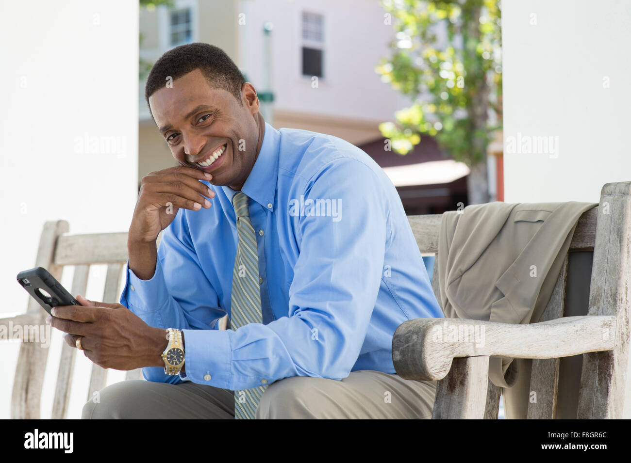 Using smart phone on urban bench hi-res stock photography and images ...
