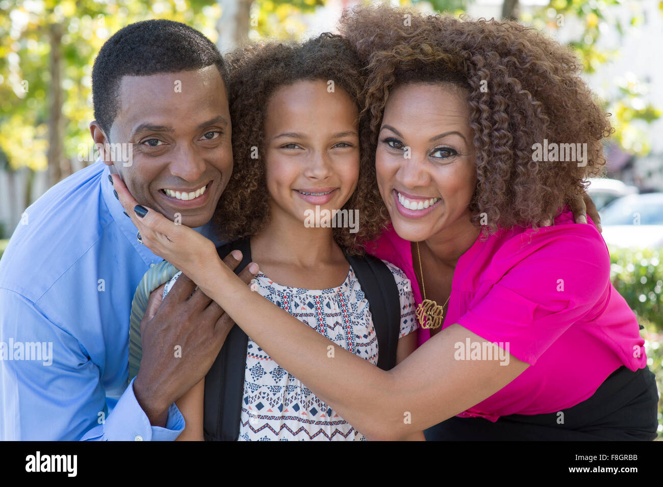 Smiling family hugging outdoors Stock Photo - Alamy