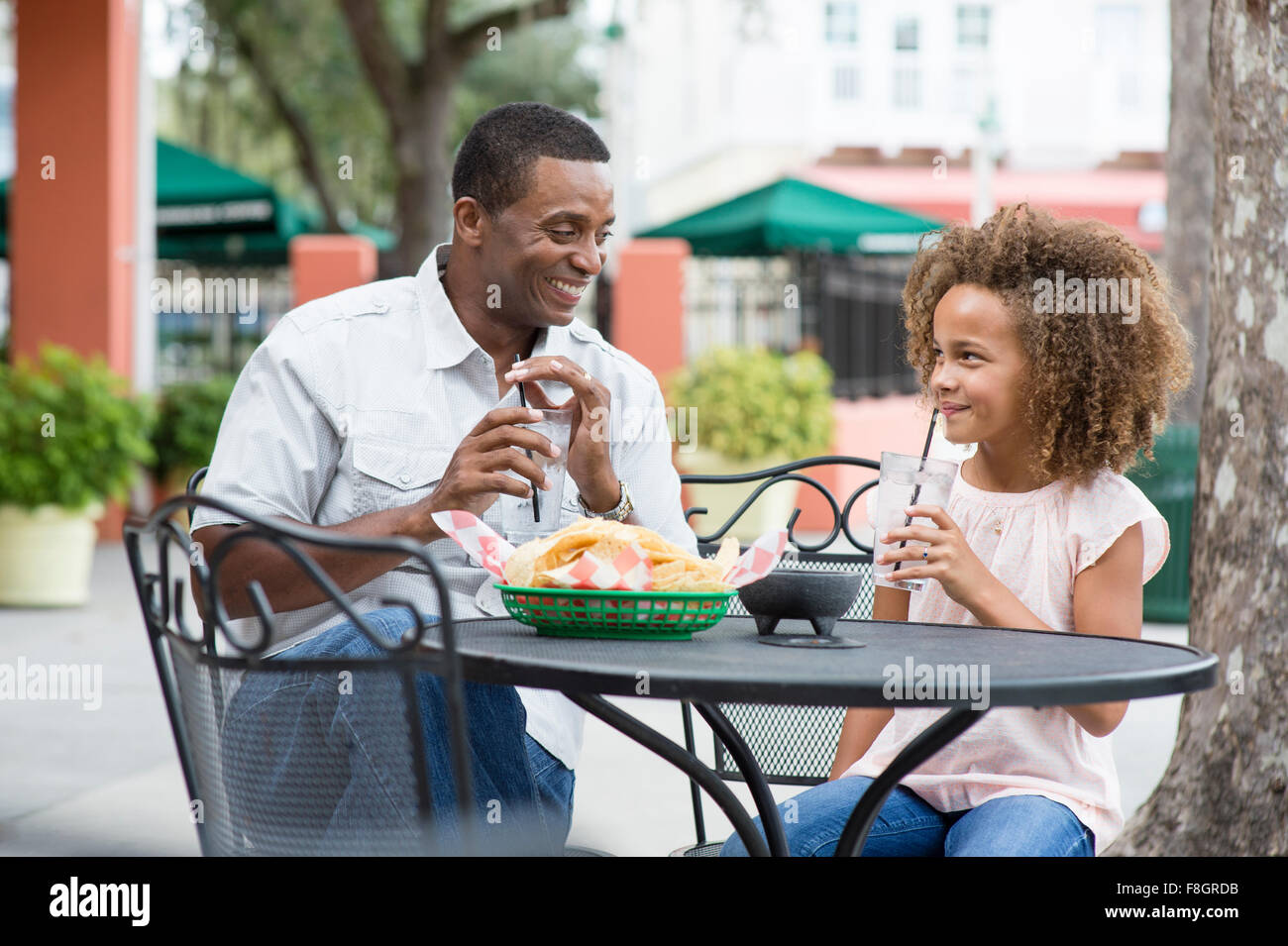 Father and daughter eating at outdoor restaurant table Stock Photo - Alamy