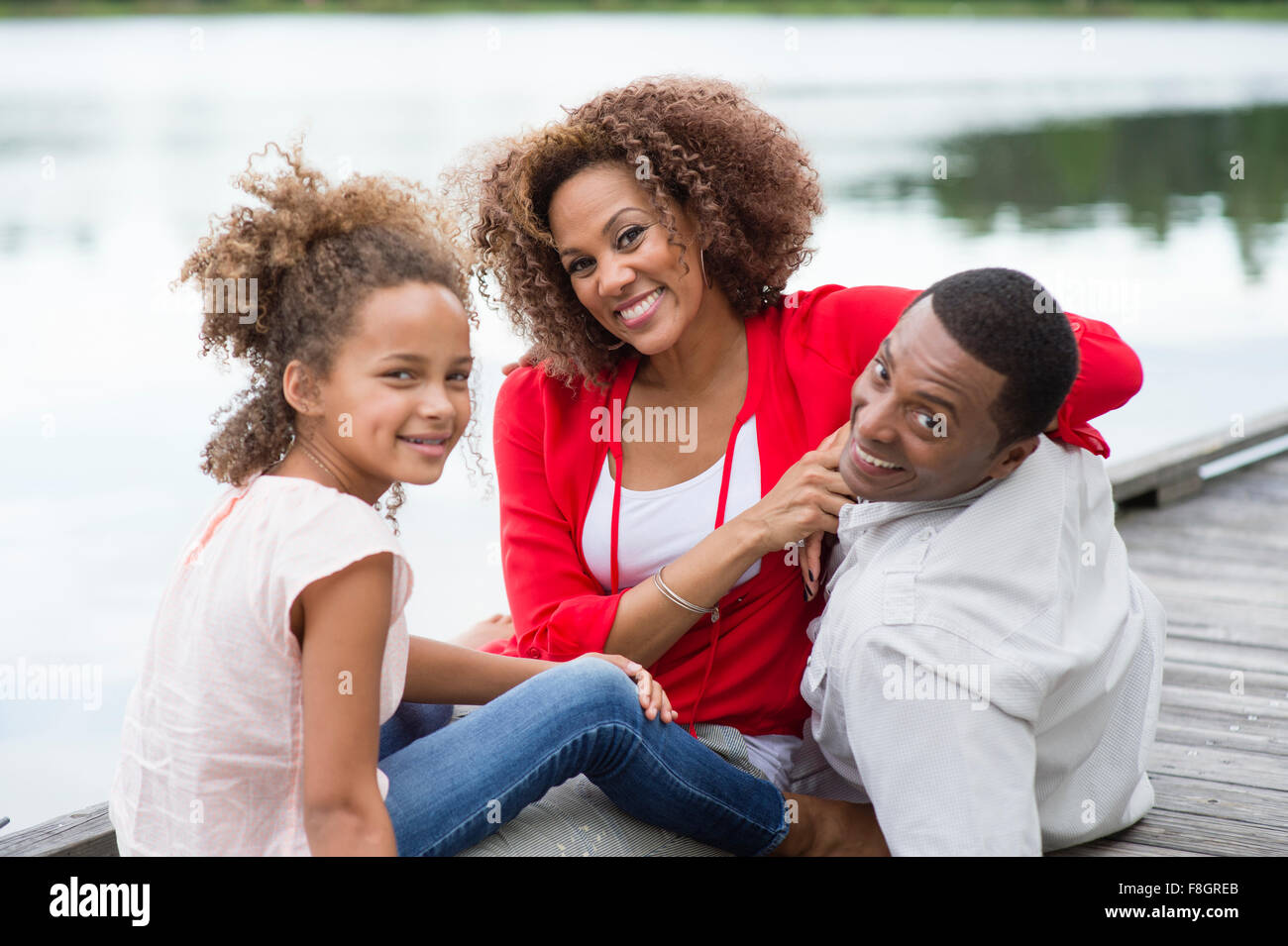 Family smiling on wooden dock Stock Photo - Alamy