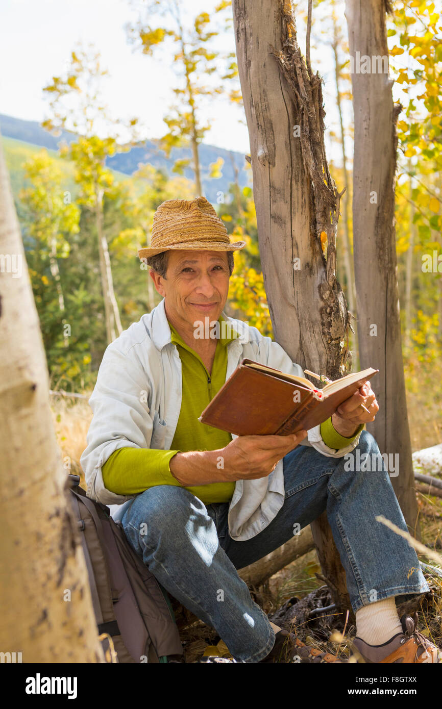 Man reading book in autumn forest Stock Photo - Alamy