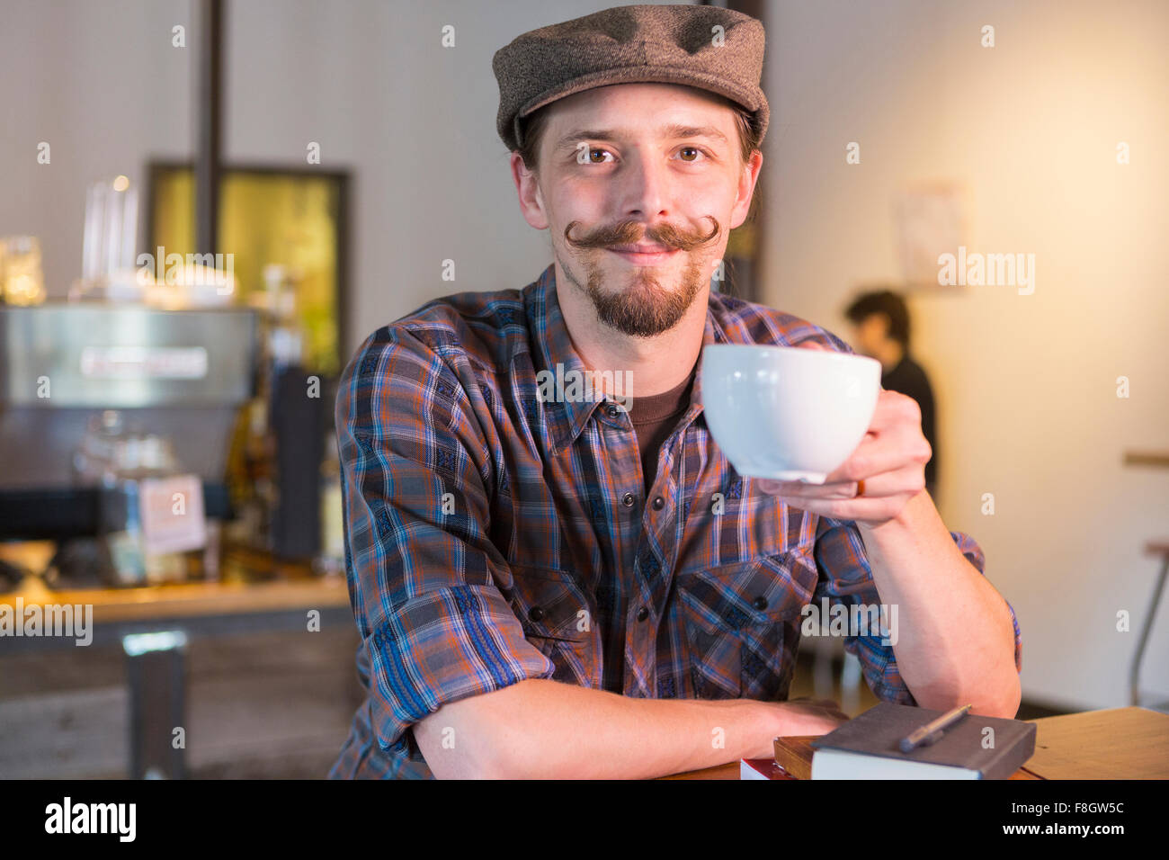Caucasian man drinking coffee in cafe Stock Photo - Alamy