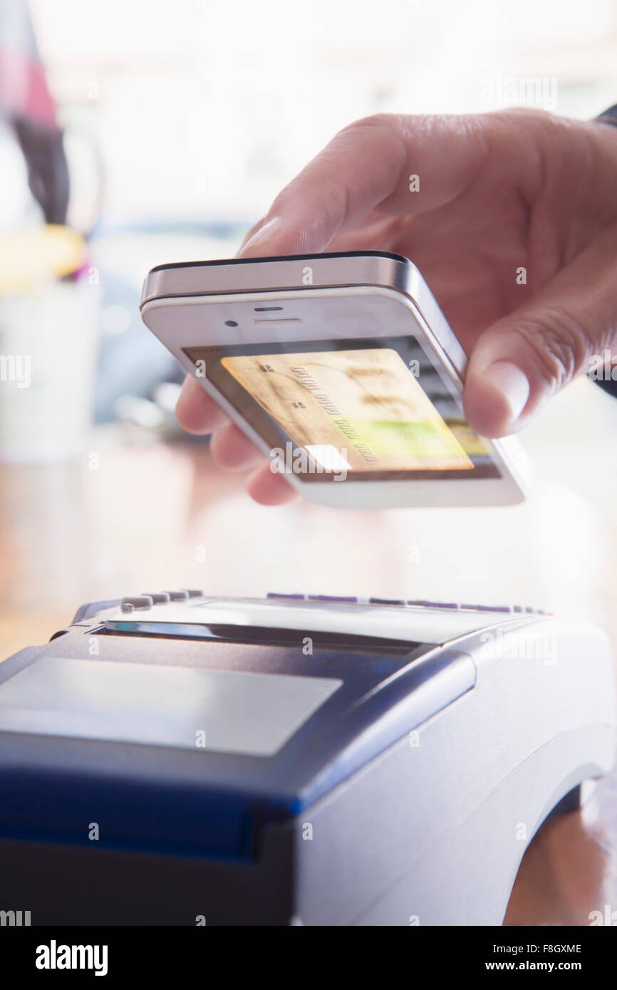 Hispanic woman scanning credit card from cell phone Stock Photo - Alamy