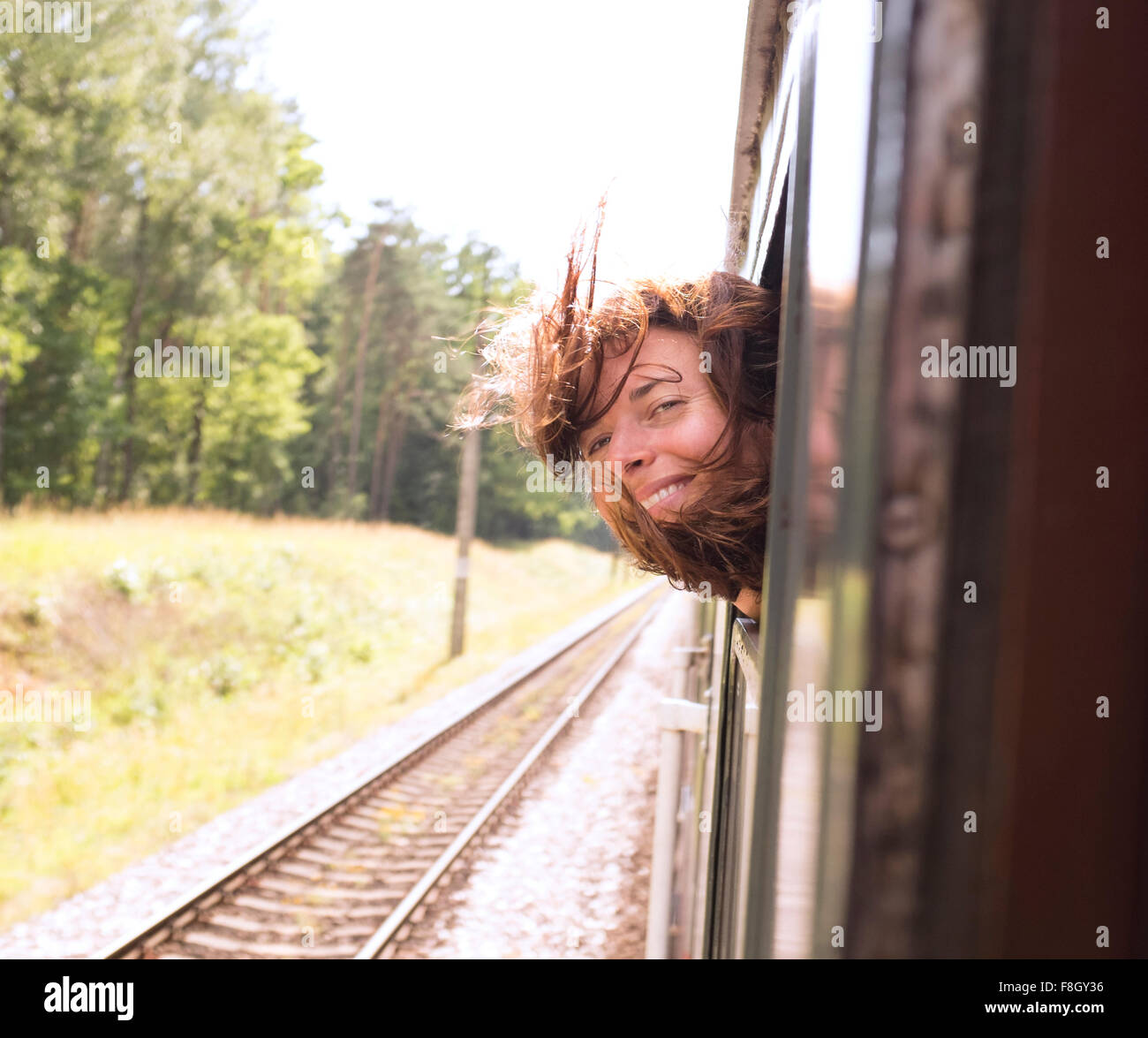 Hispanic woman with head out train window Stock Photo - Alamy