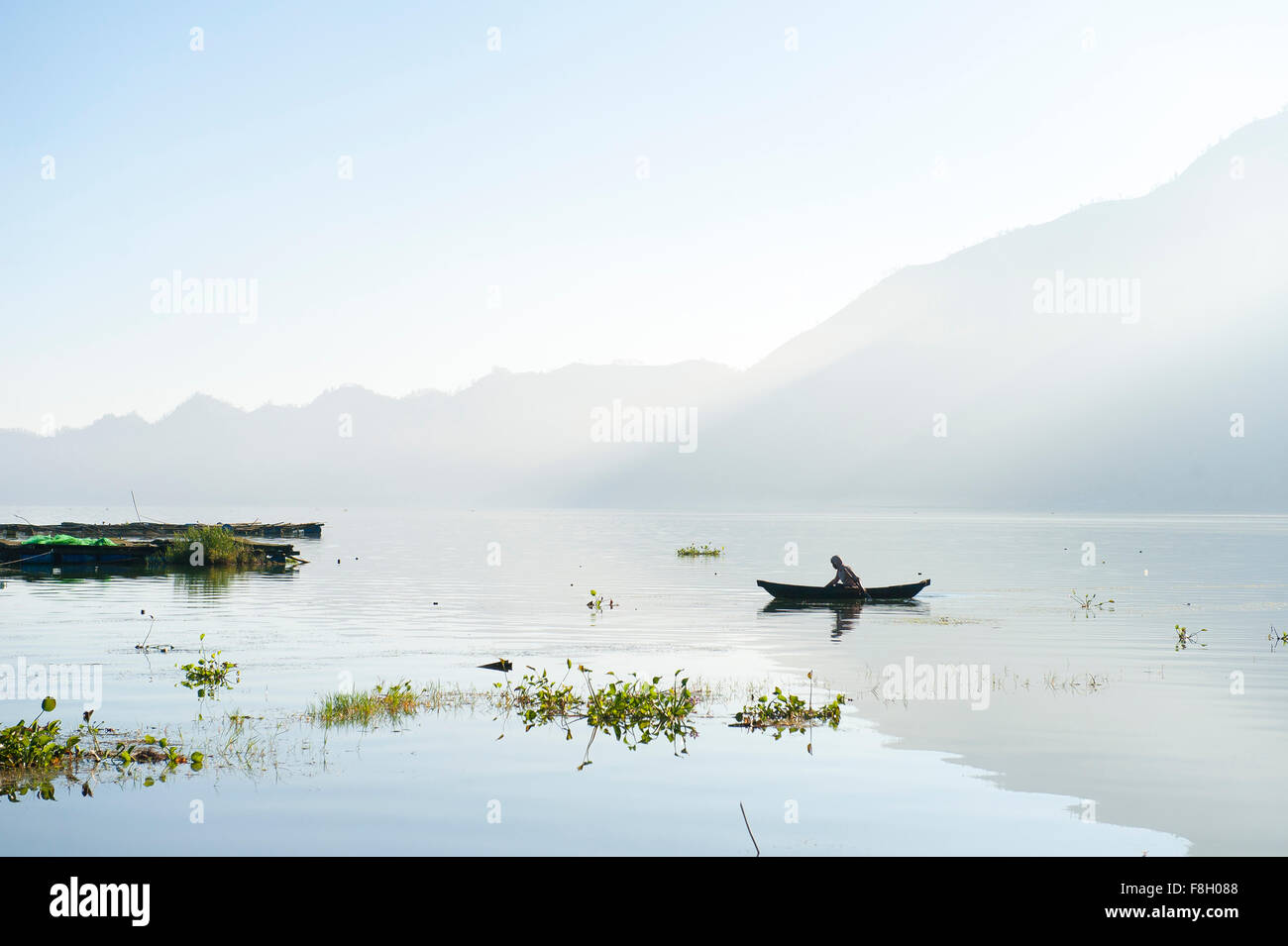 Man rowing canoe on still remote lake Stock Photo - Alamy