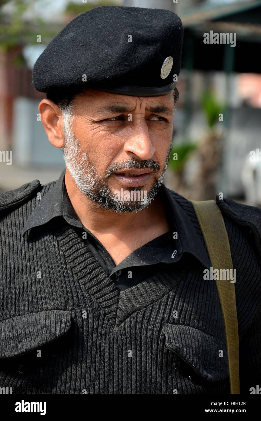 Portrait of Pathan police officer in grey sweater and police hat ...