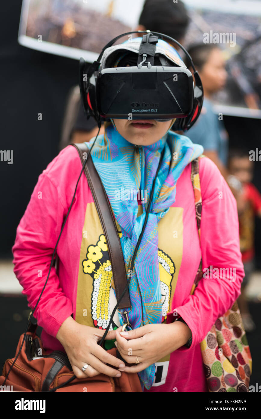 A visitor looking into a virtual reality display on rainforest ...