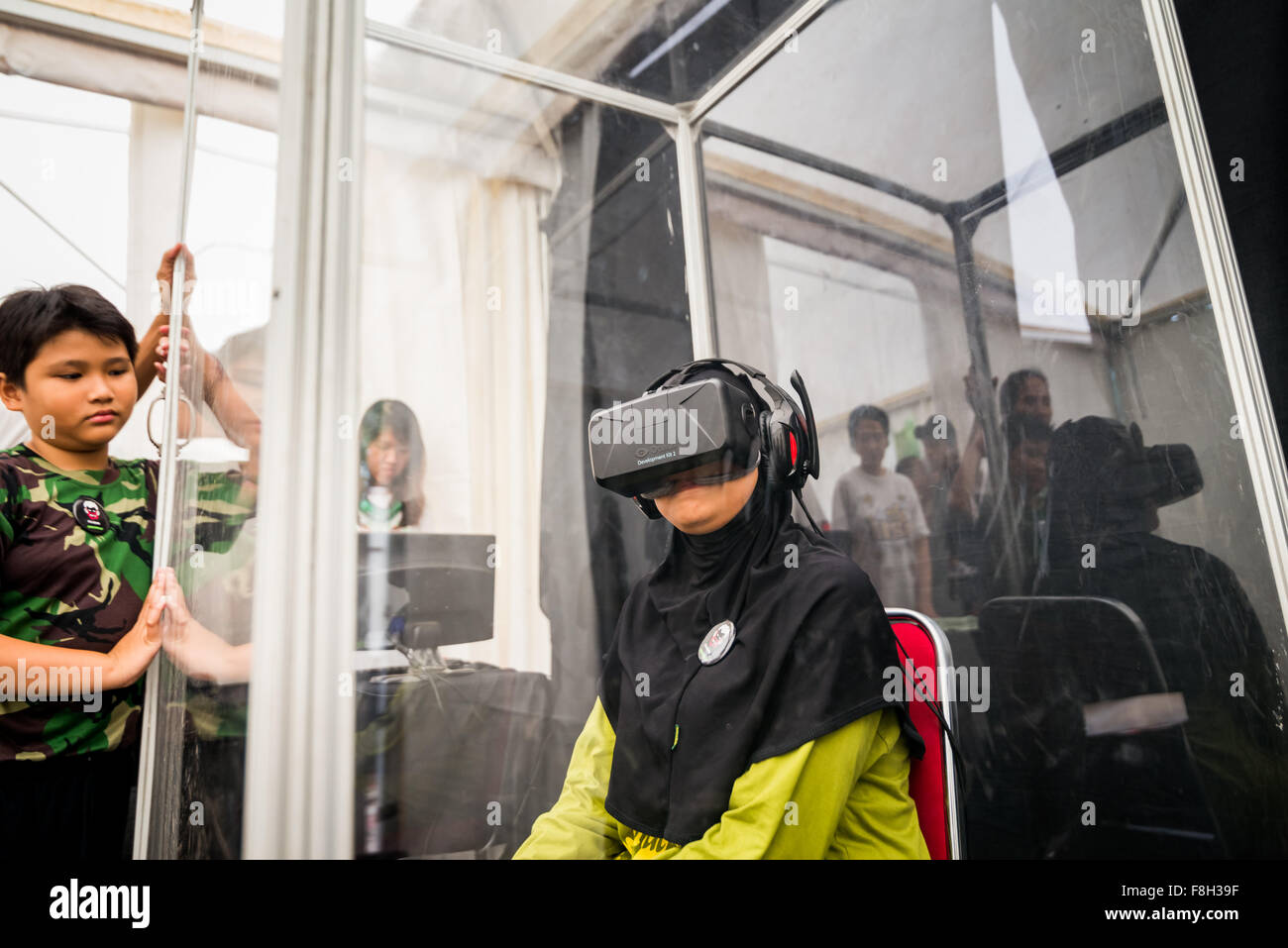 A visitor looking into a virtual reality display on rainforest ...
