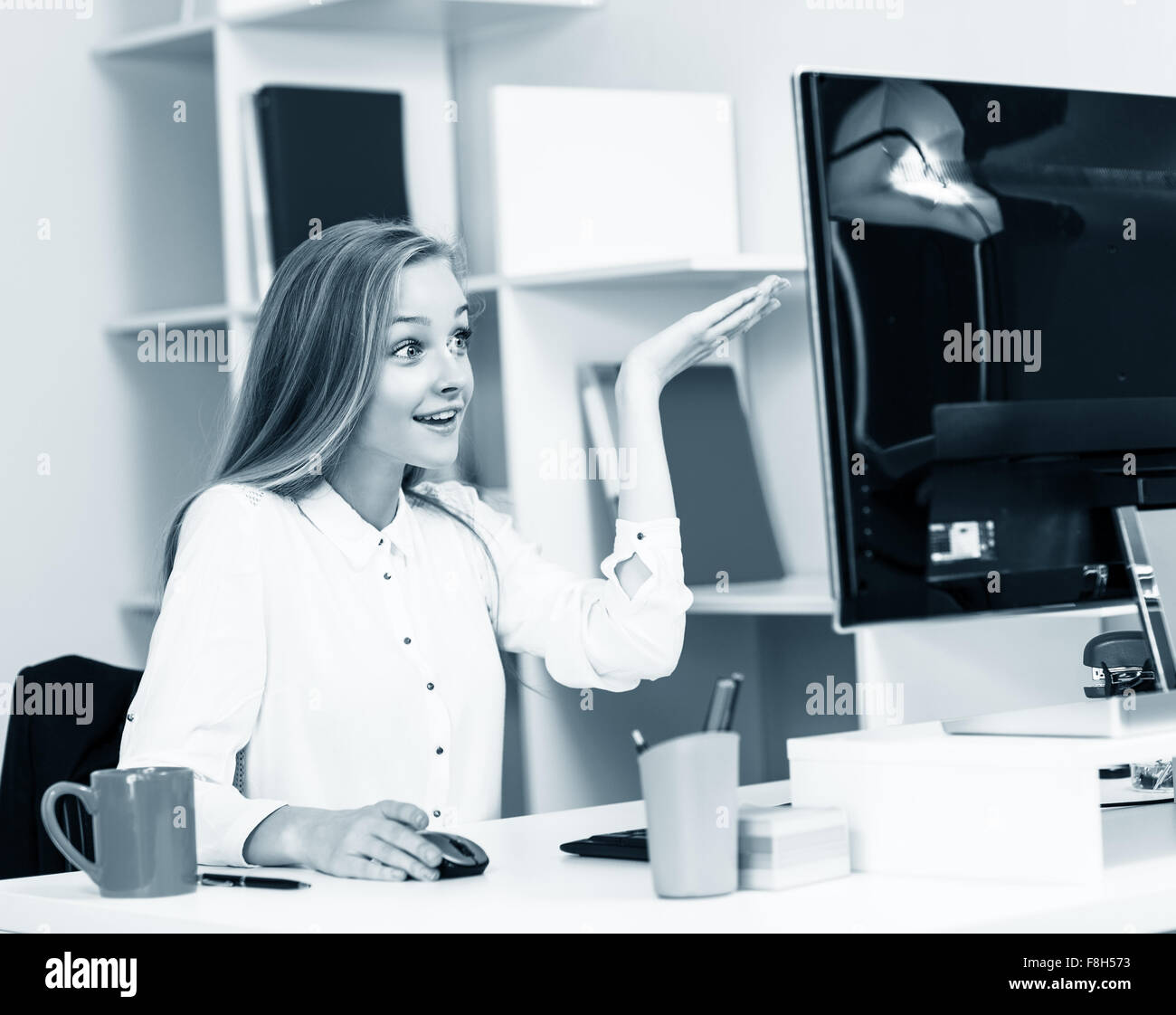 Woman sitting at the desk with computer Stock Photo - Alamy