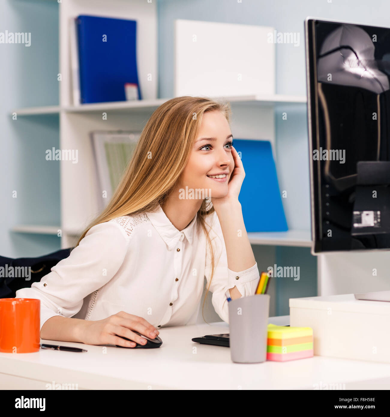 Woman sitting at the desk with computer Stock Photo - Alamy