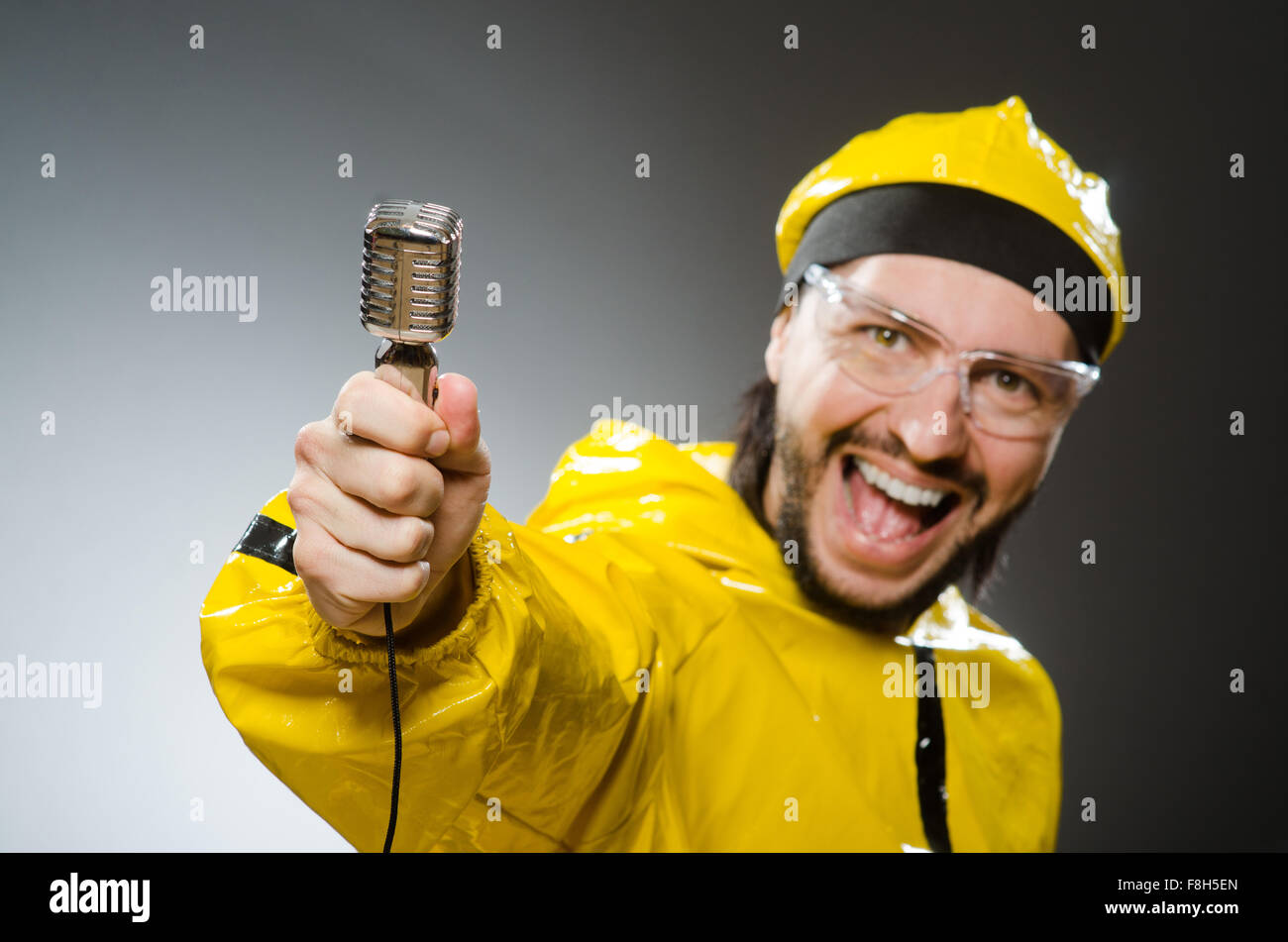 Man wearing yellow suit with mic Stock Photo - Alamy