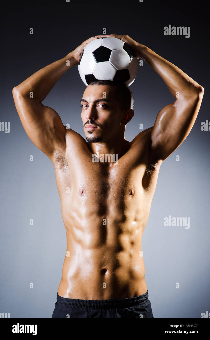 Muscular man with football ball Stock Photo - Alamy