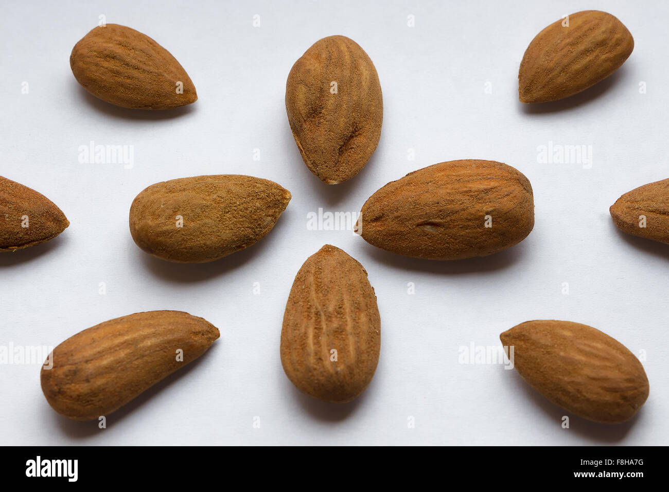 Group of ten almonds arranged on white paper background Stock Photo - Alamy