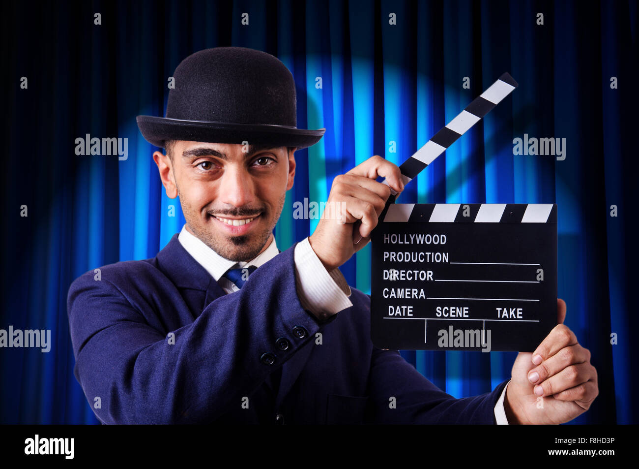Man with movie clapper on curtain background Stock Photo - Alamy