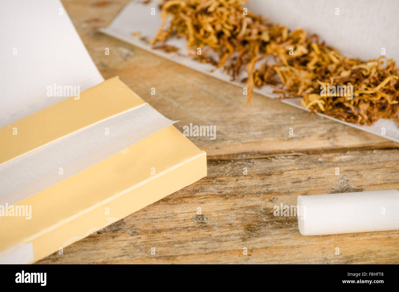 Accesories for rolling and smoking cigarettes on a rustic wooden table ...
