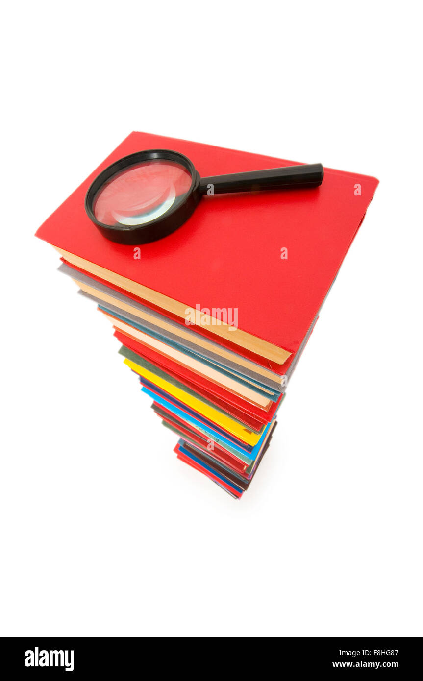 Magnifying glass over the stack of books Stock Photo - Alamy