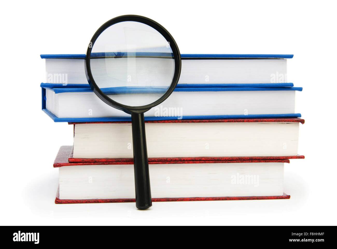 Magnifying glass over the stack of books Stock Photo - Alamy