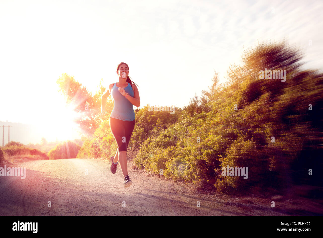 Beautiful girl running outdoors at sunset hour Stock Photo - Alamy