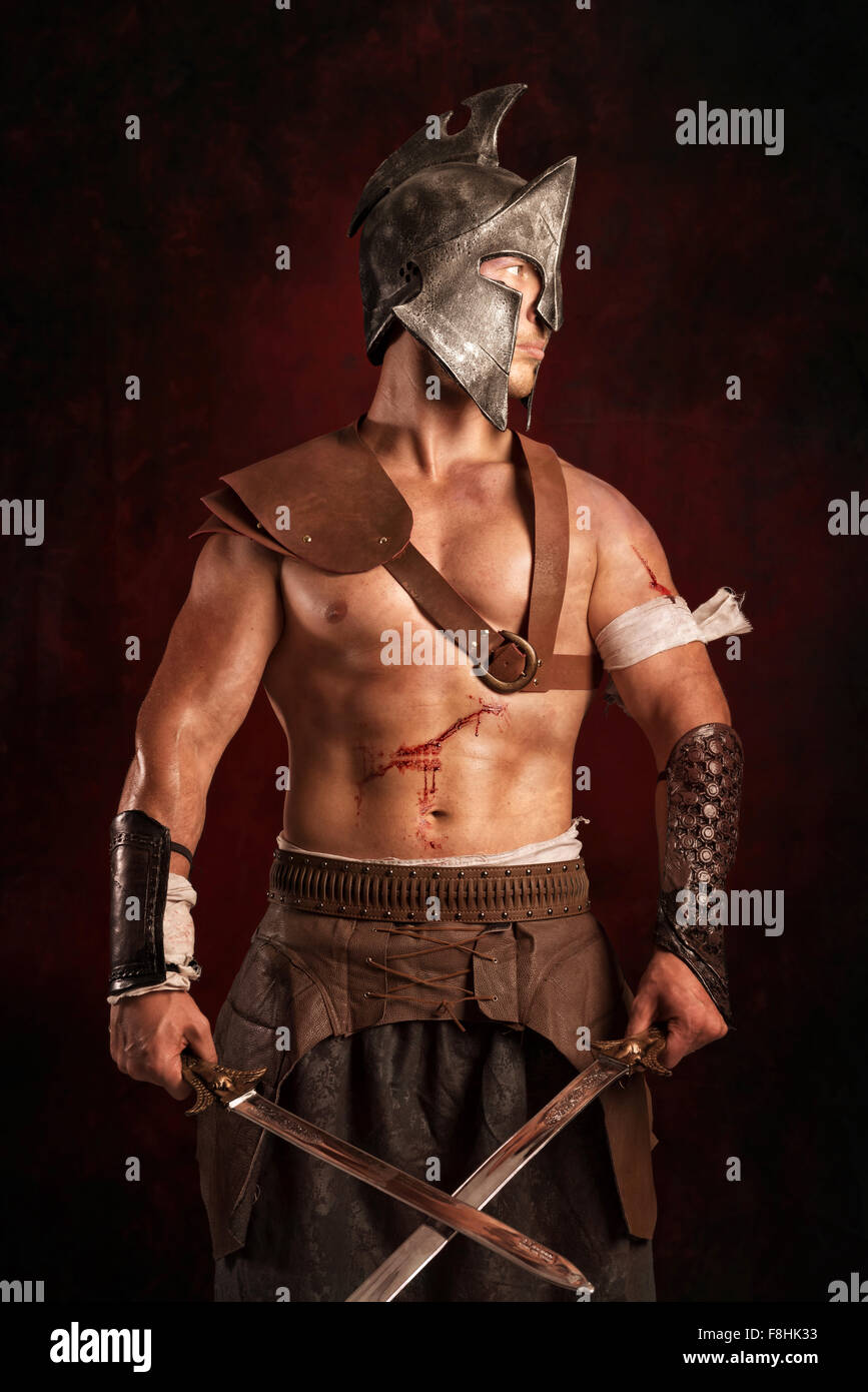 Gladiator posing isolated in a dark background Stock Photo - Alamy