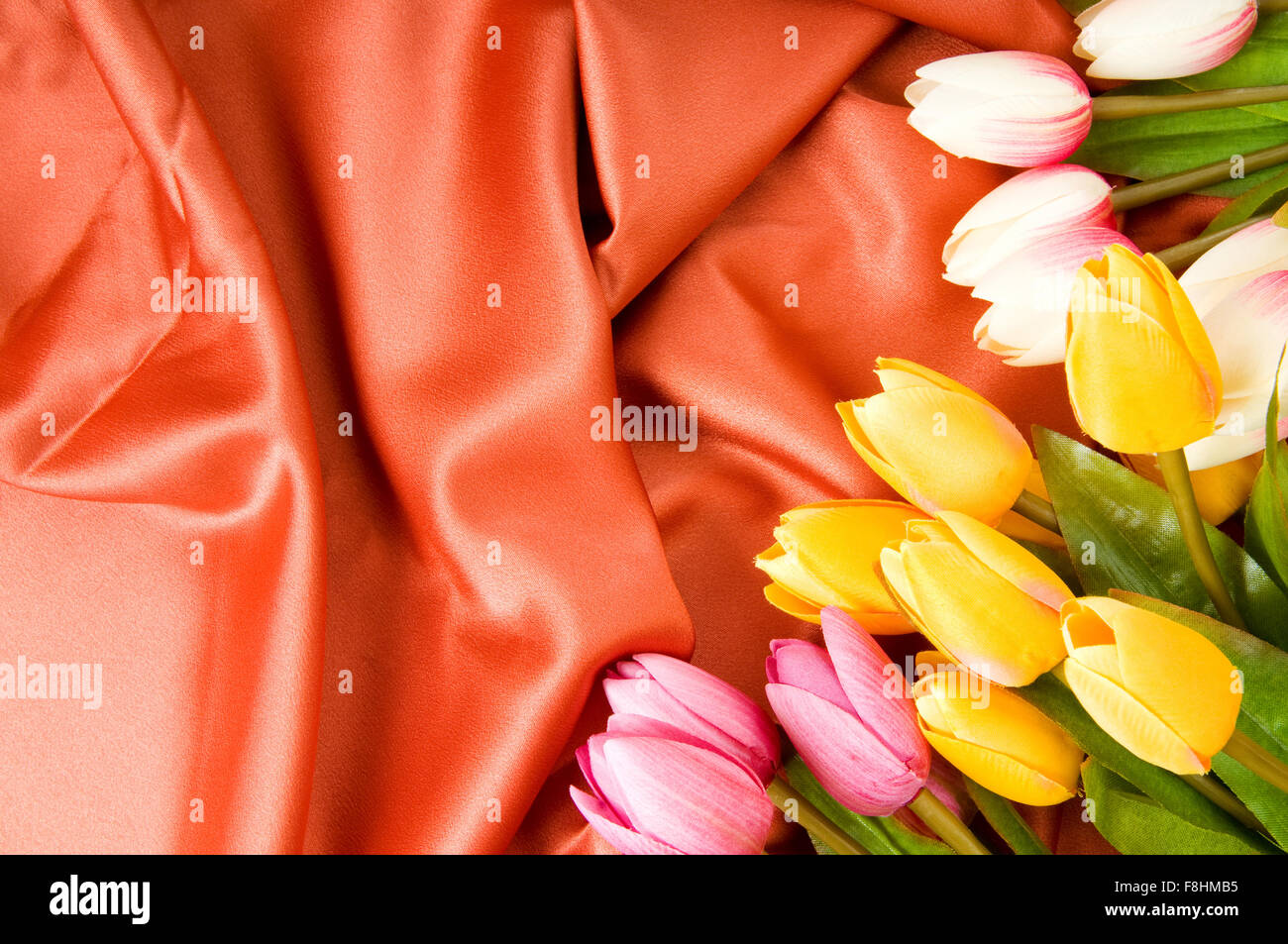 Many flowers on the red satin background Stock Photo - Alamy
