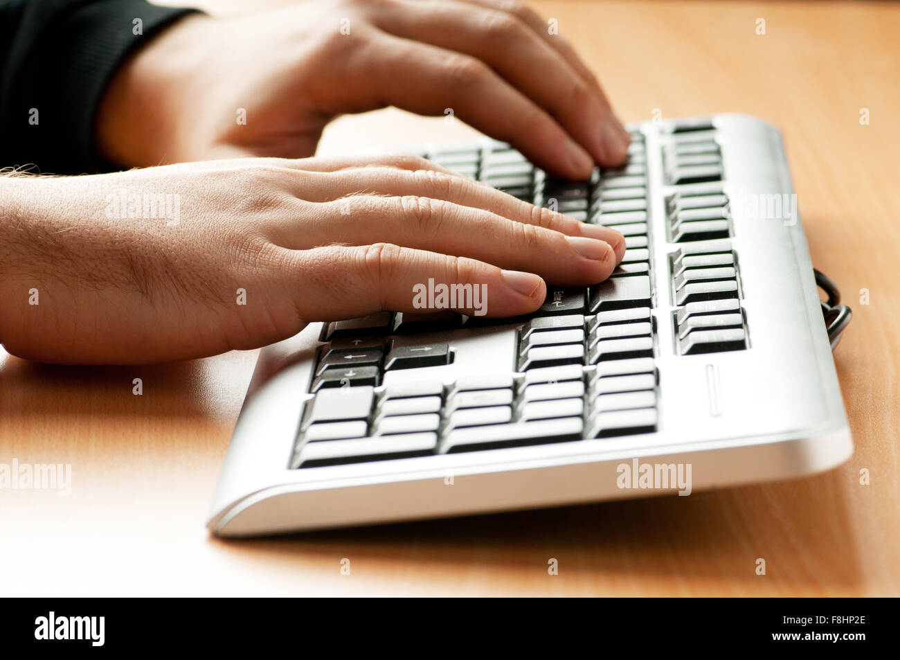 Two hands working on the silver keyboard Stock Photo - Alamy