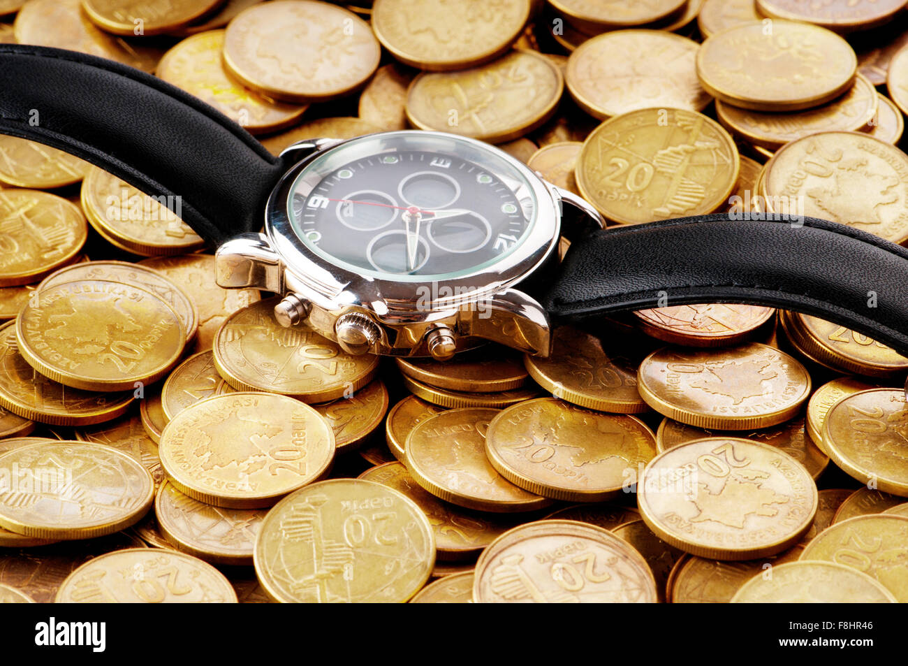 Time is money concept with watch and coins Stock Photo - Alamy