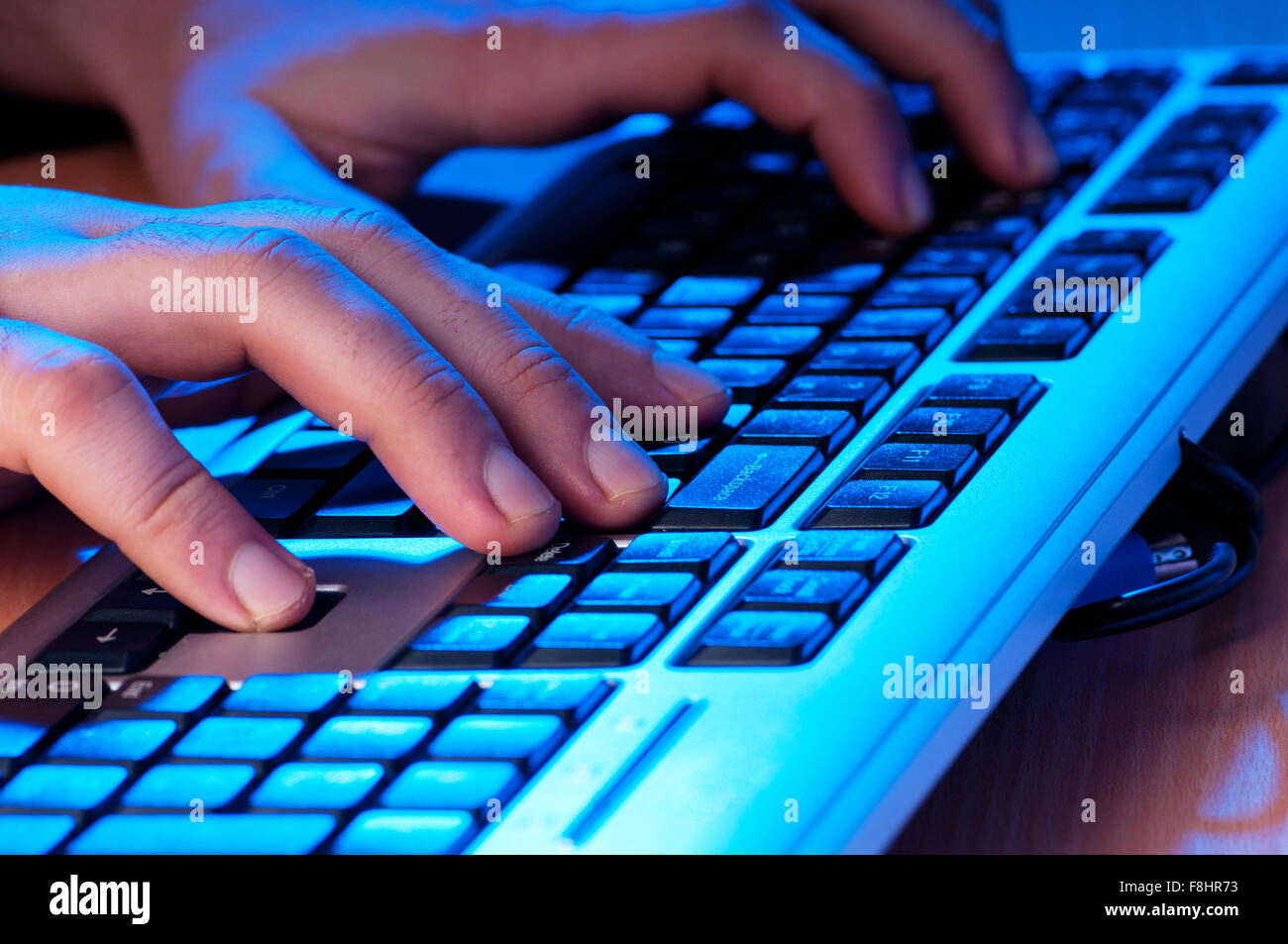 Two hands working on the silver keyboard Stock Photo - Alamy