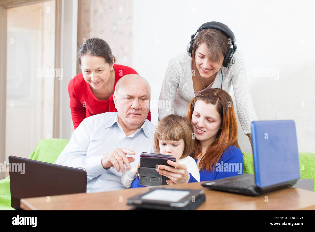 Group of people uses few various devices at home interior Stock Photo ...