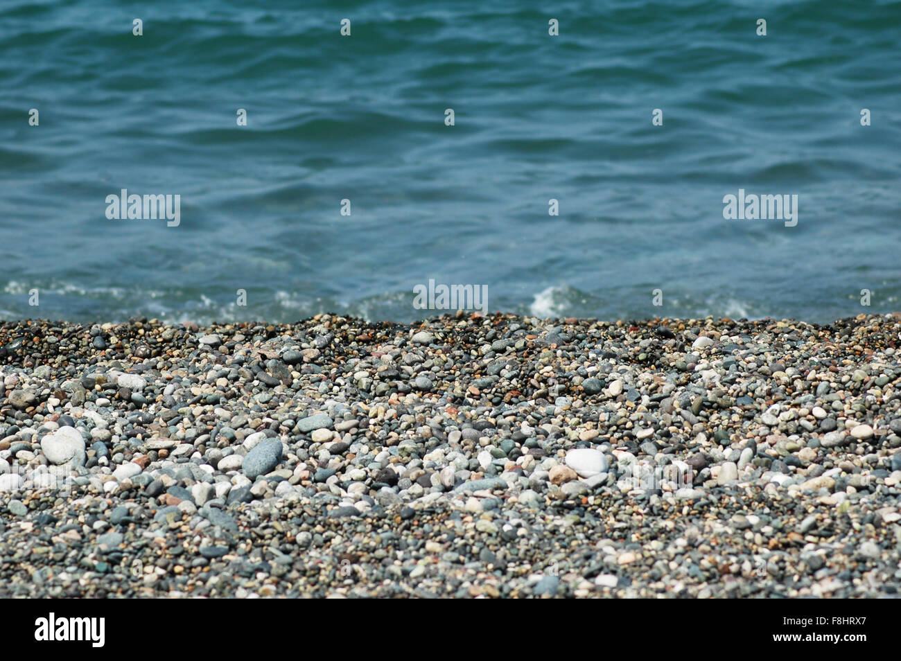 Water and small pebbles at the beach Stock Photo - Alamy