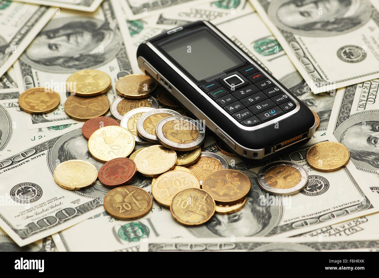 Mobile phone with coins and dollar bank notes Stock Photo - Alamy