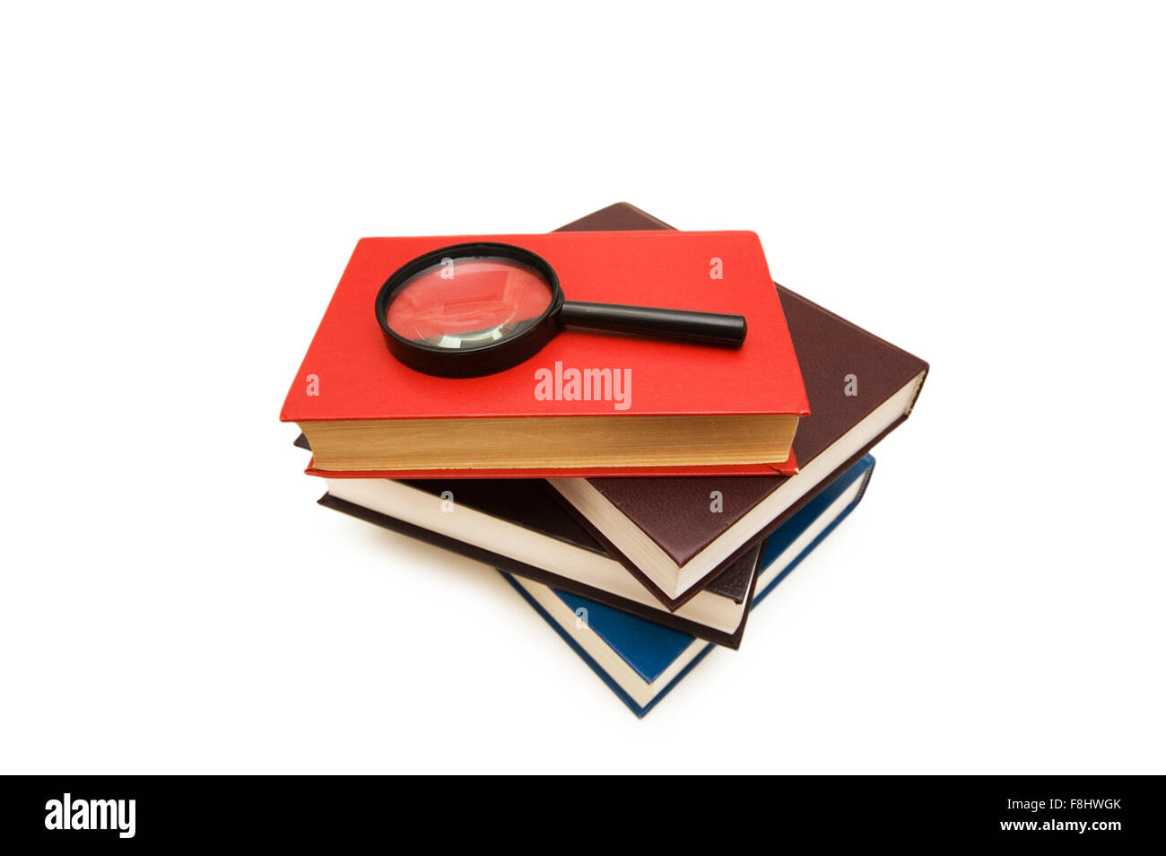 Magnifying glass over the stack of books Stock Photo - Alamy