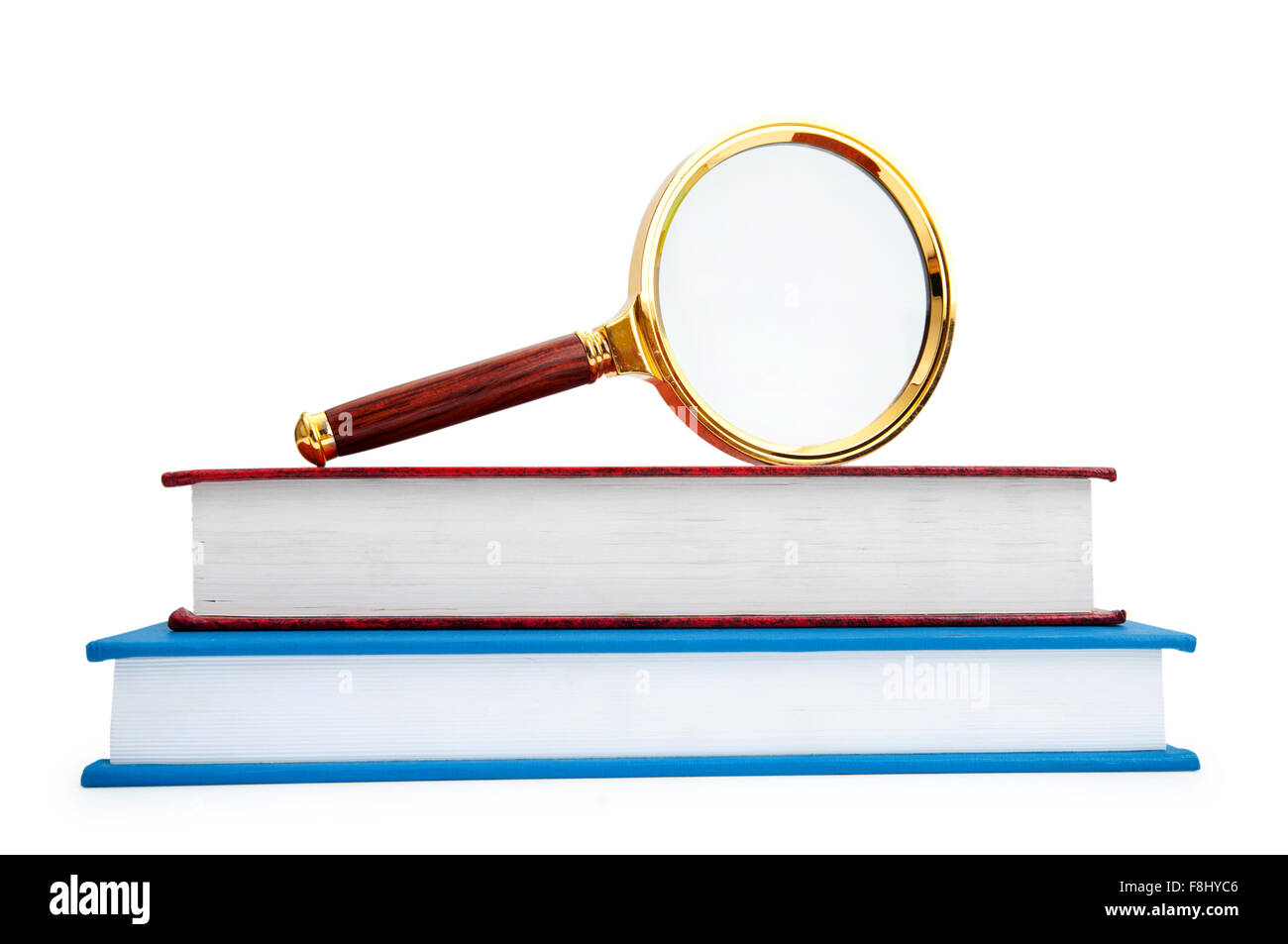 Magnifying glass over the stack of books Stock Photo - Alamy