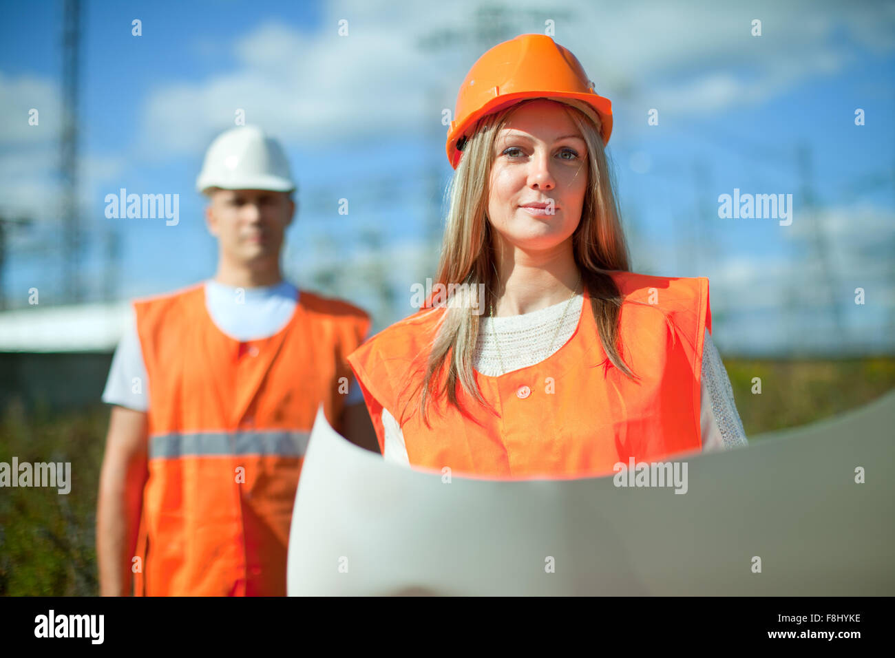 two workers wearing protective helmet works at electrical power station ...