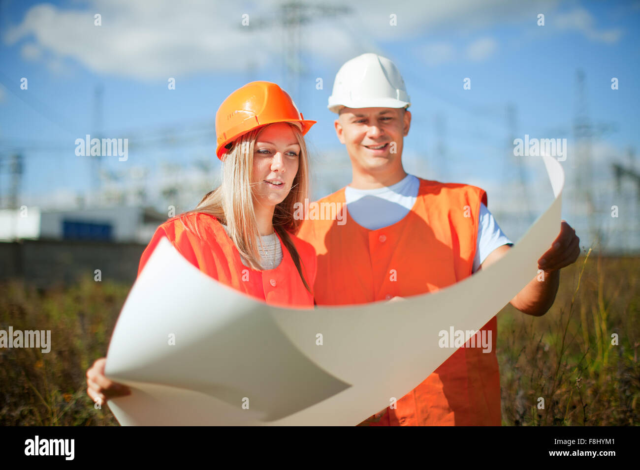 two workers wearing protective helmet works at electric power plant ...