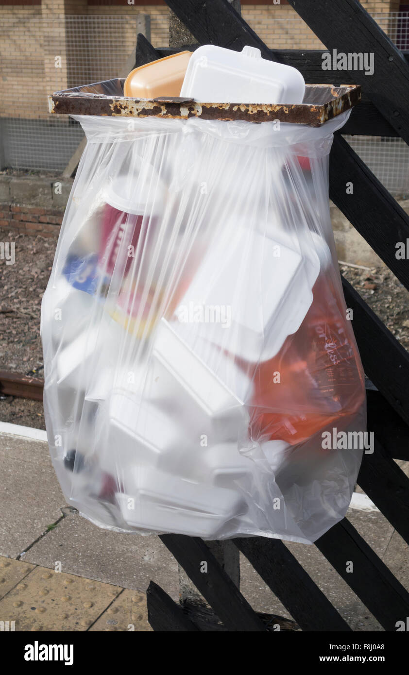 Plastic litter bin full of styrofoam takeaway food trays on railway ...