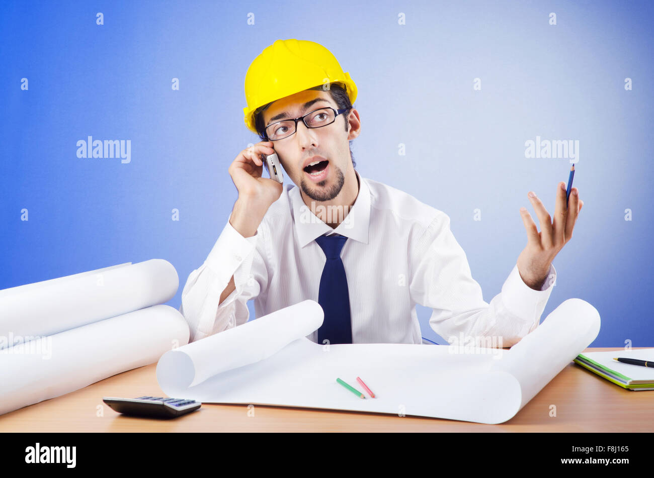 Young engineer looking at drawings Stock Photo - Alamy