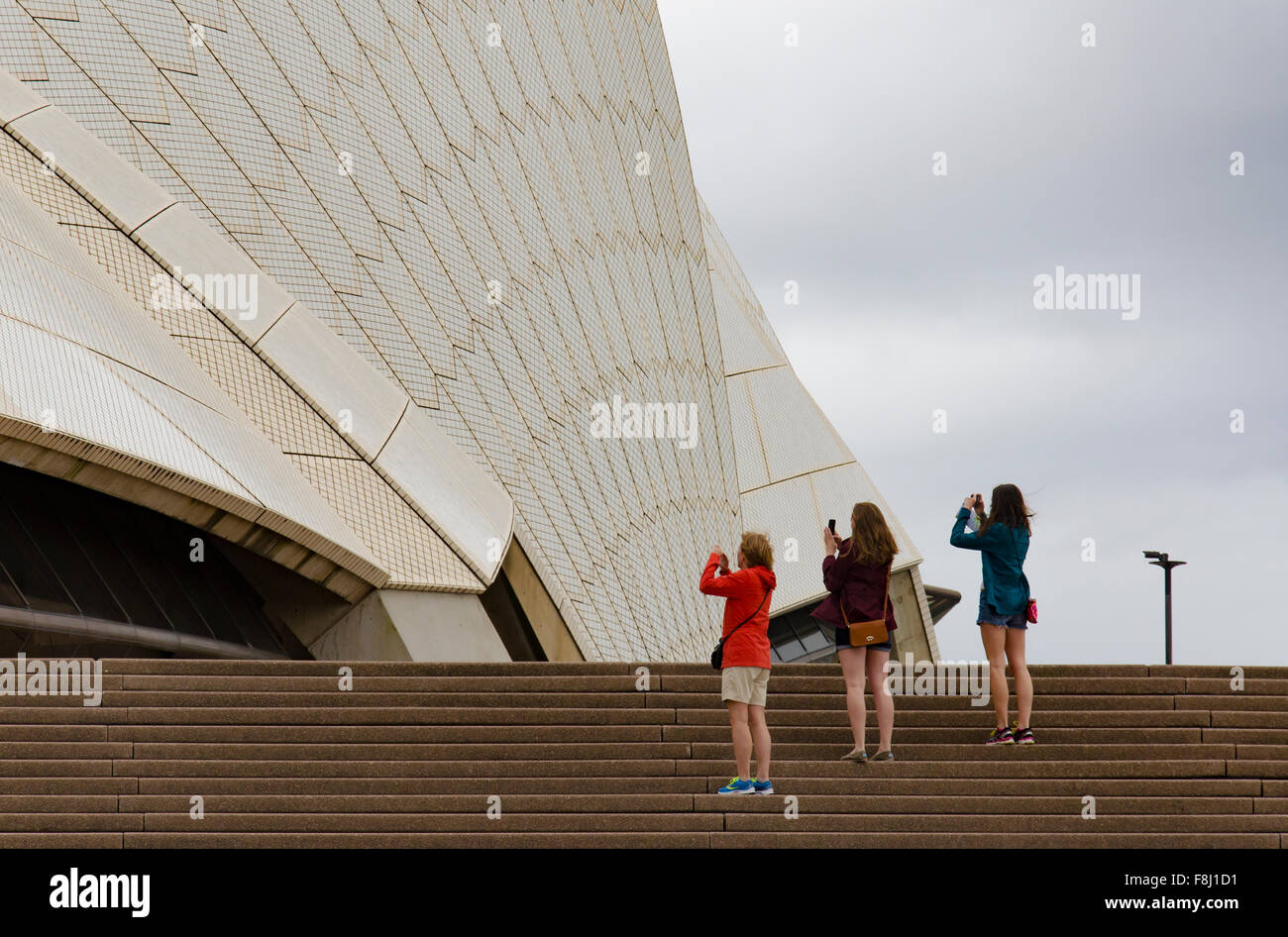 Three women in a line using IPhones to photograph the Sydney Opera ...