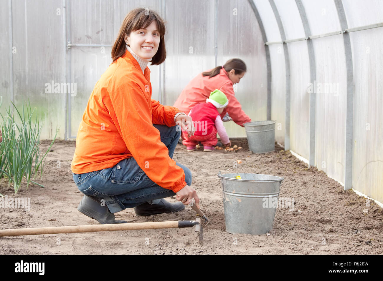 Happy family sows seeds in soil at greenhouse Stock Photo - Alamy